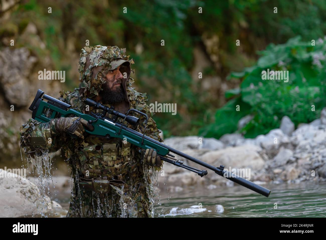 A military man or airsoft player in a camouflage suit sneaking the ...