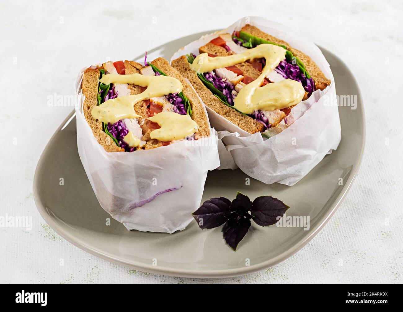 Sandwich with chicken fillet, red cabbage and sauce, wrapped in paper ...