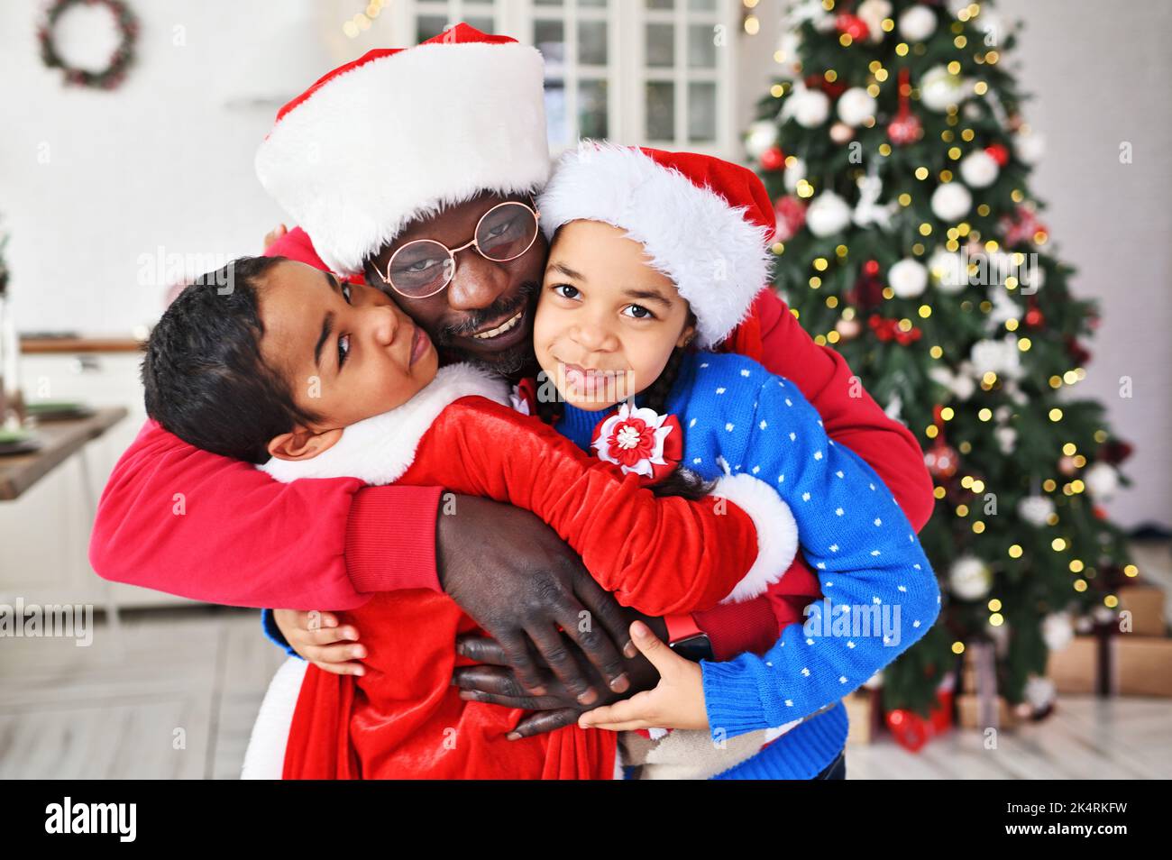 dad and children - a daughter and son dressed in a Santa costume with a ...