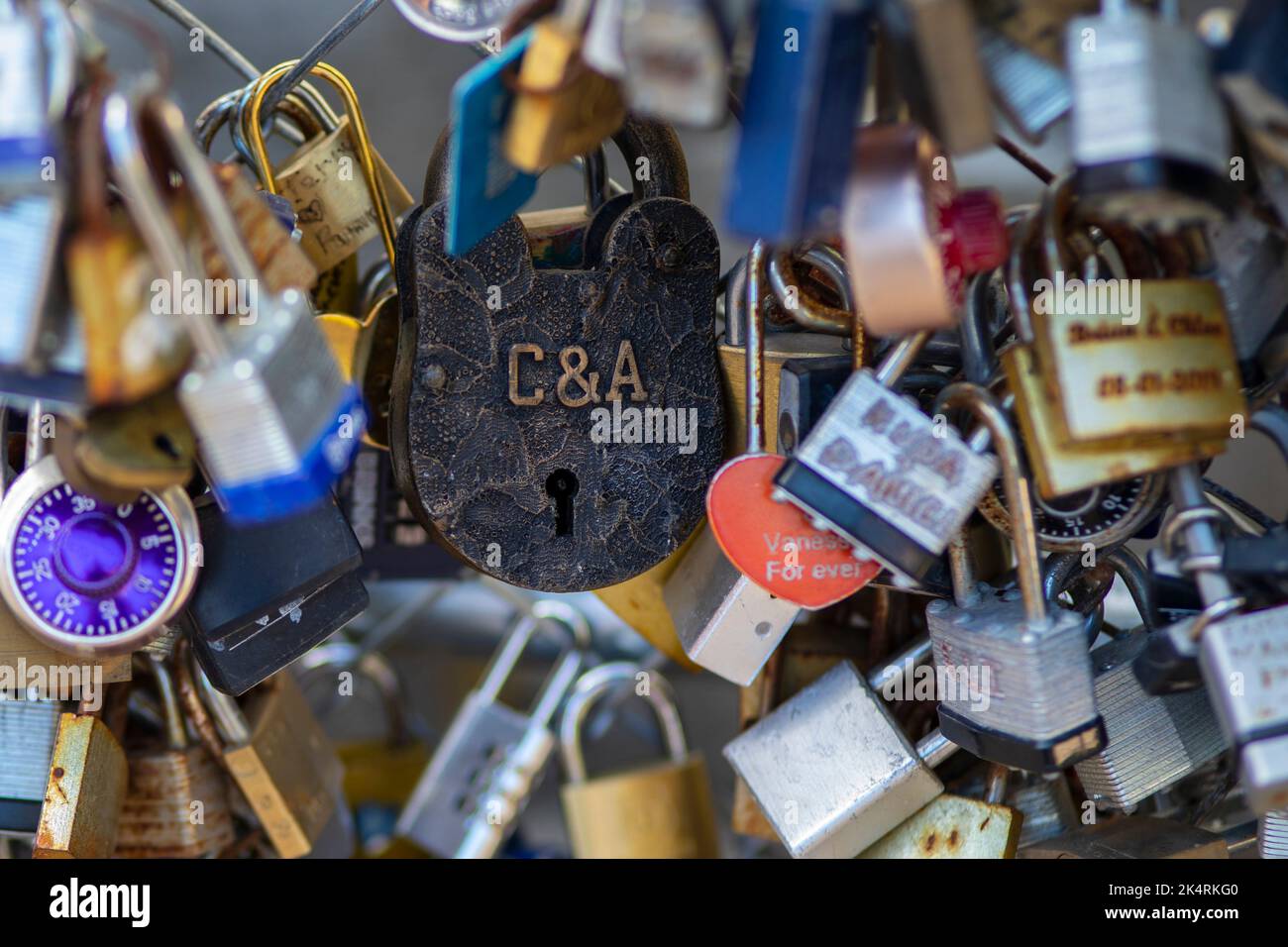 Old and new padlocks with names and dates written on them lock on a ...