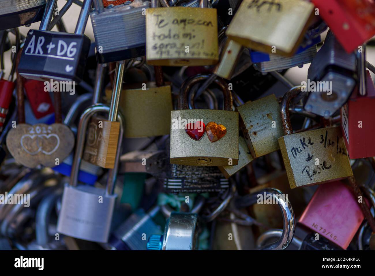 Old and new padlocks with names and dates written on them lock on a ...
