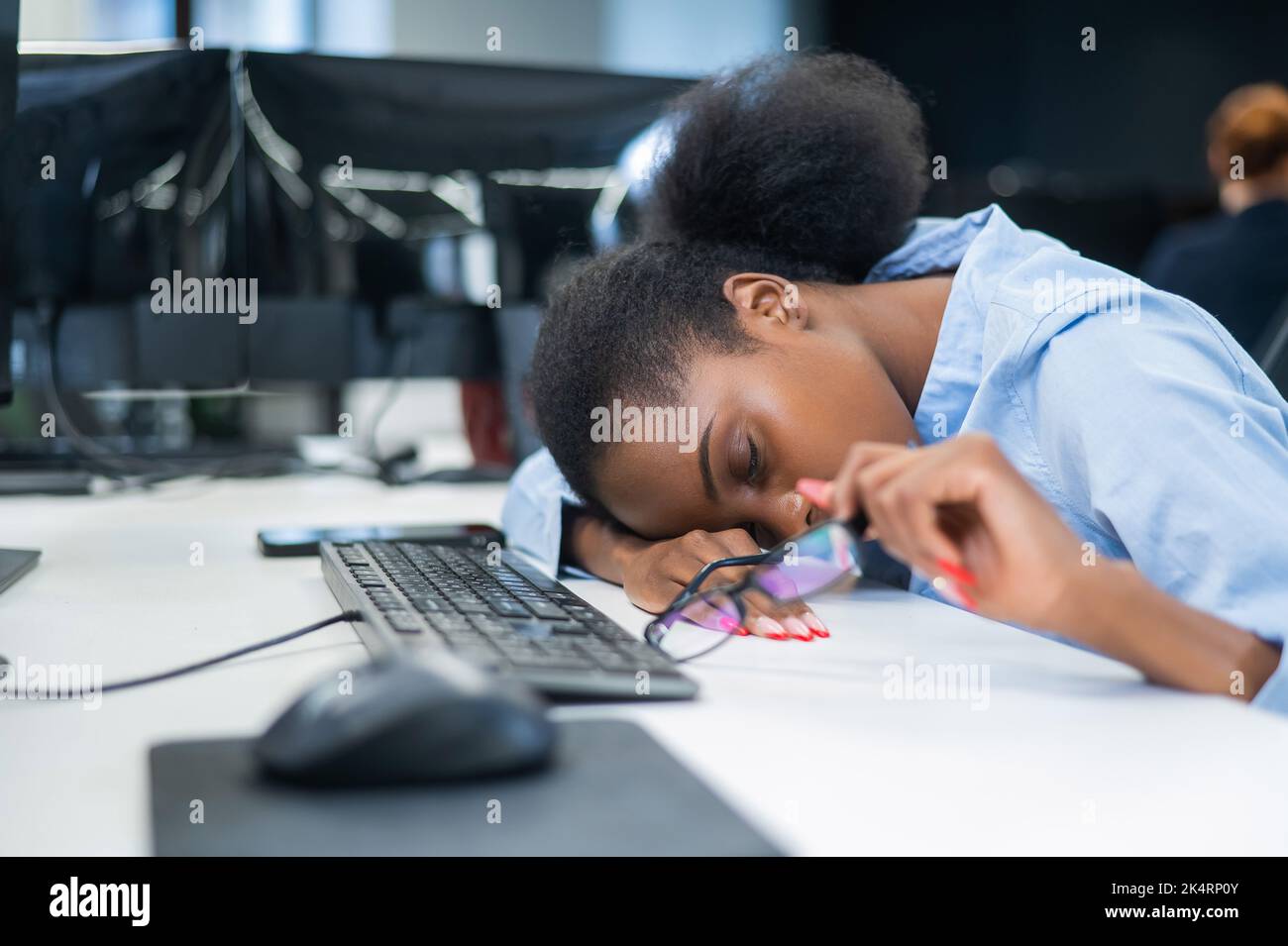 African young woman sleeping at work desk Stock Photo - Alamy