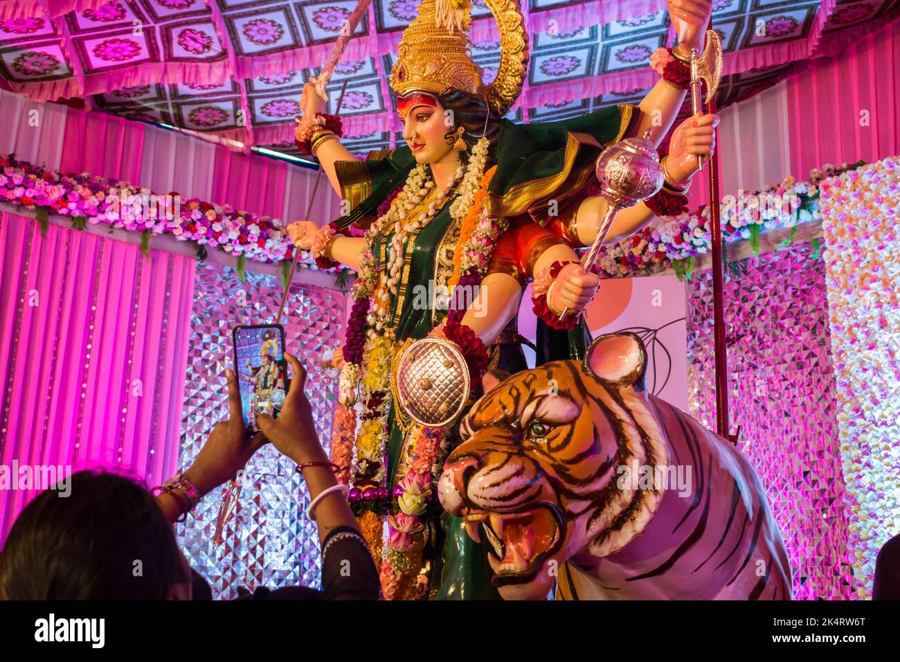 A woman clicking a picture of an idol of Maa Durga at a mandal in ...