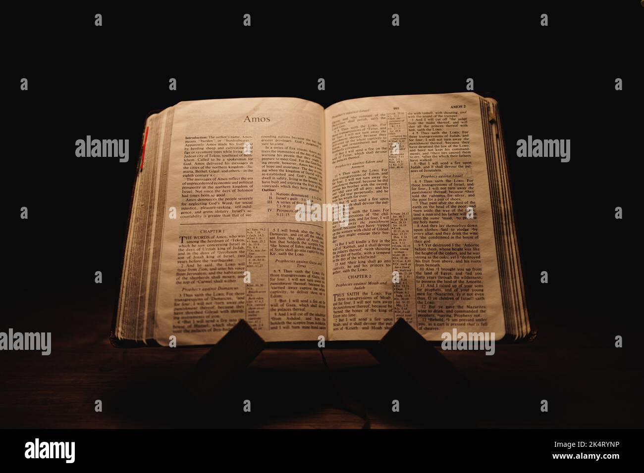 A closeup shot of a historic old Bible open on the Amos pages on ...