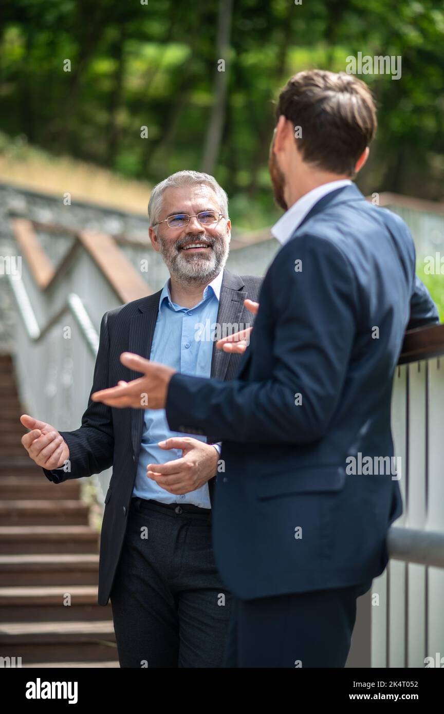 Two businessmen discussing the project details and looking involved ...