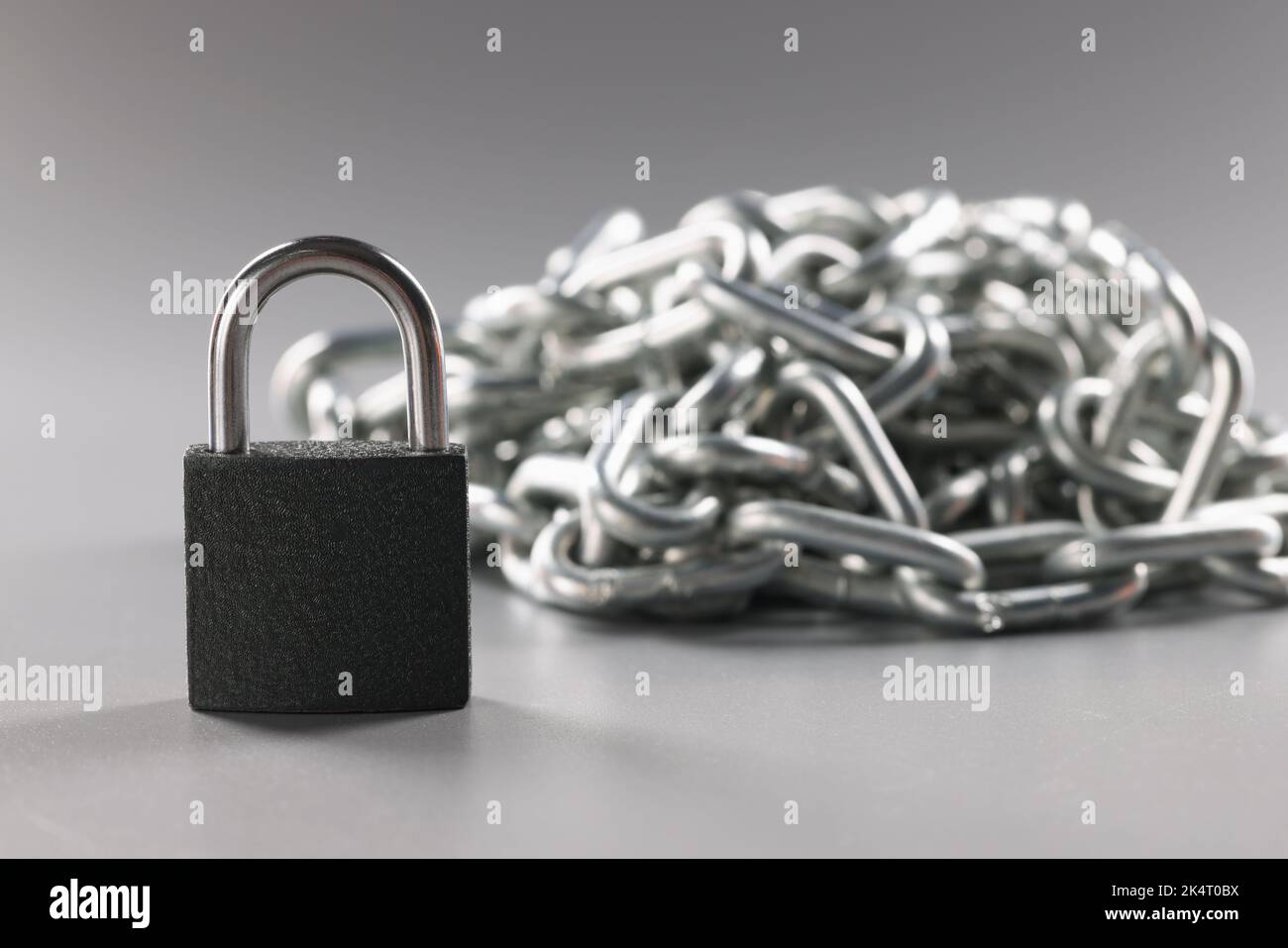 Padlock and metal chains on a gray background Stock Photo - Alamy