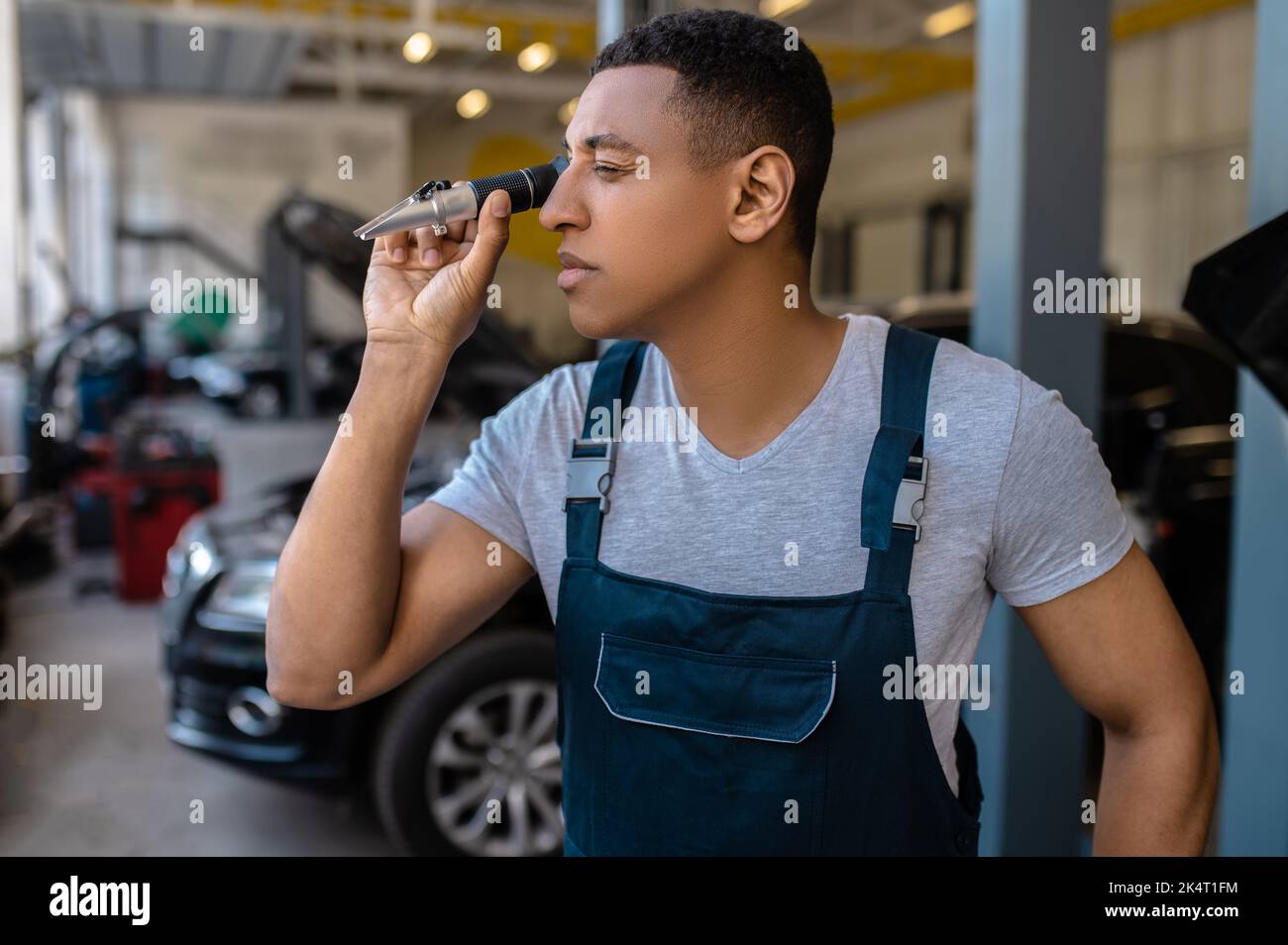 Concentrated auto service worker checking a new component Stock Photo ...