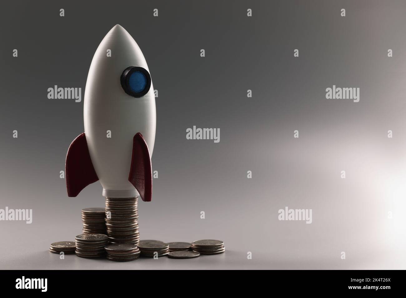 Plastic rocket on top of a stack of coins, close-up Stock Photo - Alamy