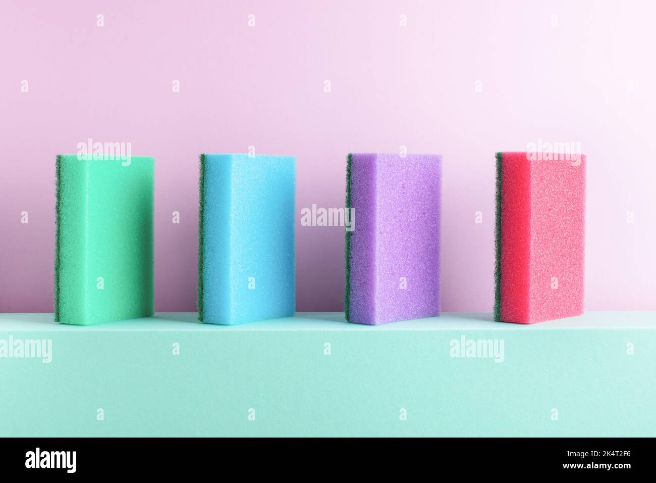 Many colored kitchen sponges on decorative colourful podium. Front view ...
