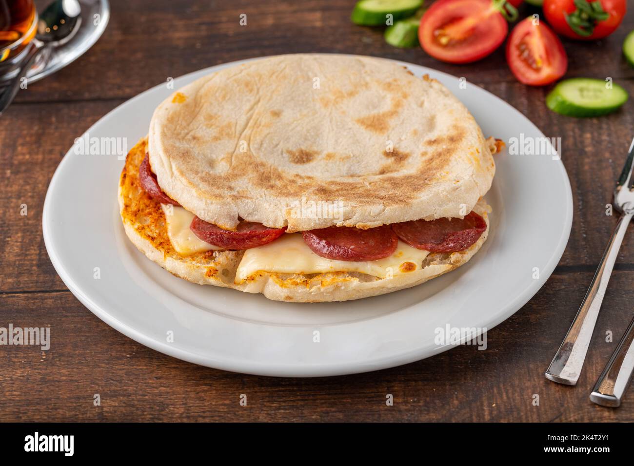 Flatbread toast with salami, turkish sausage and cheddar on a dark ...