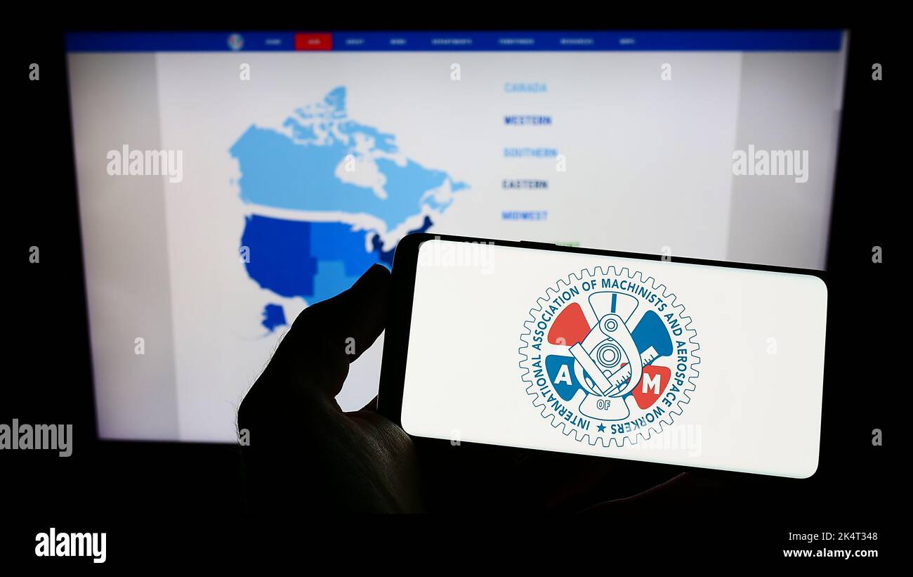 Person holding smartphone with logo of American-Canadian trade union ...