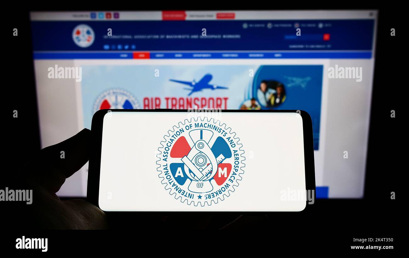 Person holding cellphone with logo of American-Canadian trade union IAM ...