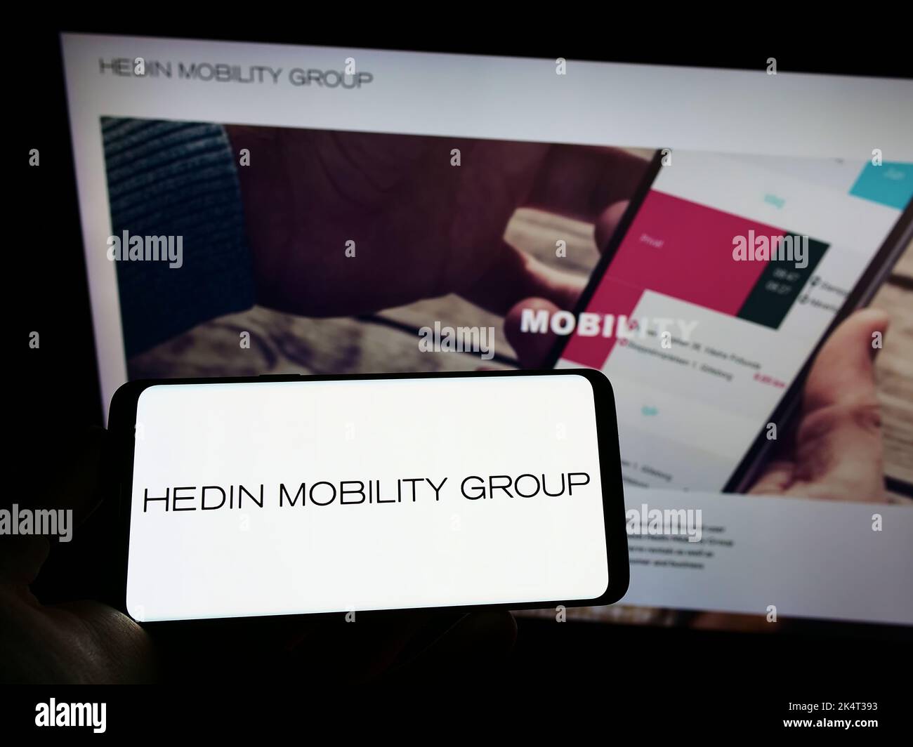 Person holding cellphone with logo of Swedish company Hedin Mobility ...