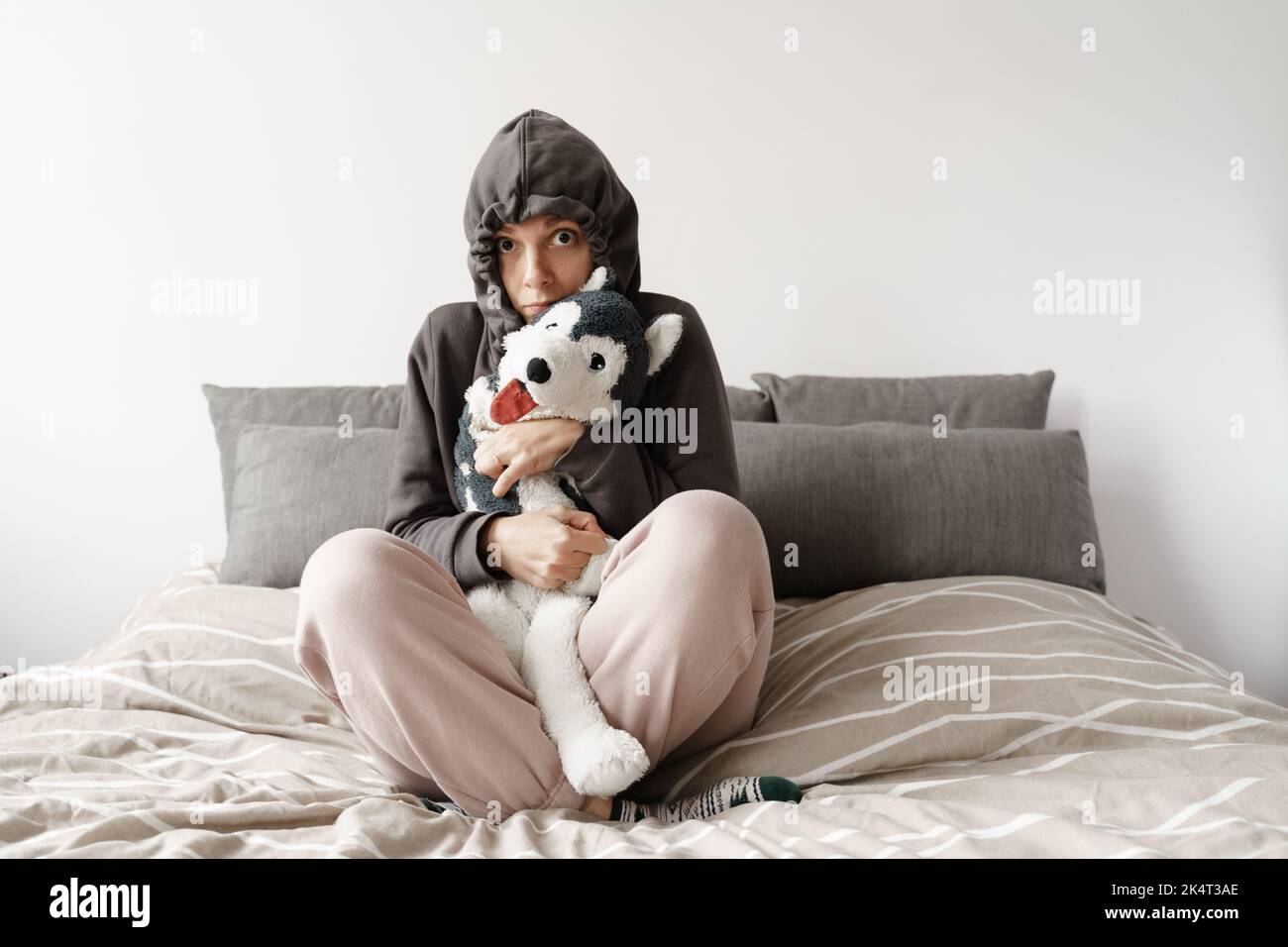 Young woman freezing and dressing up at cold home. Power energy crisis ...