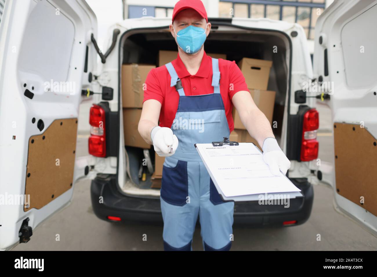 The delivery man holds out documents for signature Stock Photo - Alamy