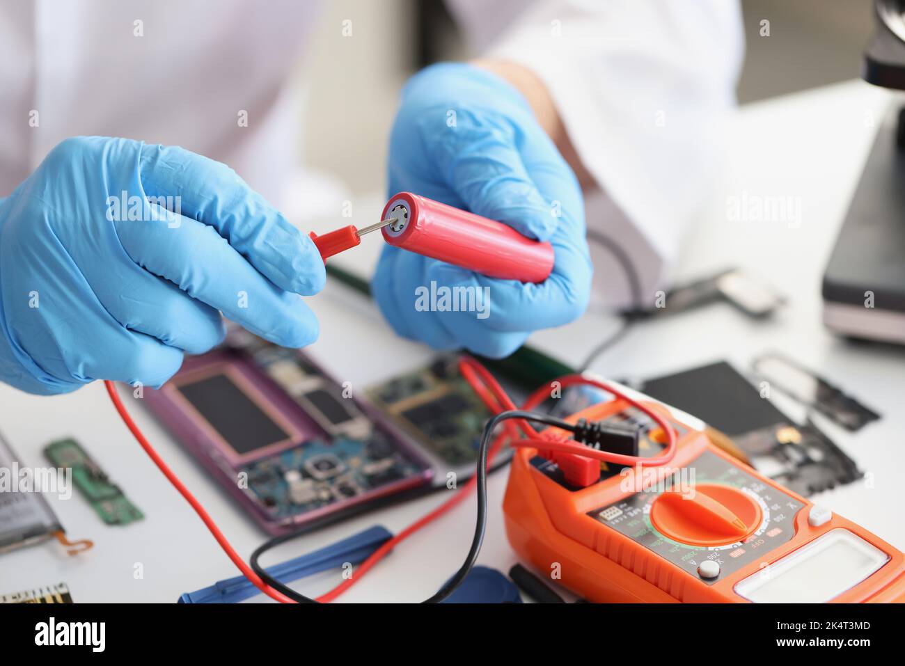 Hands hold a red lithium titanium battery and a voltmeter Stock Photo ...