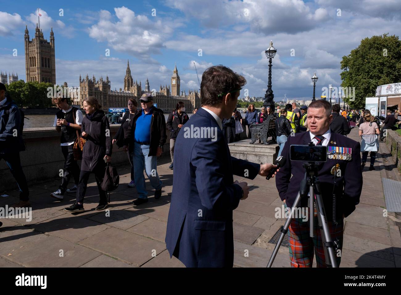 TV coverage as long queues of people on the riverside walkway opposite ...