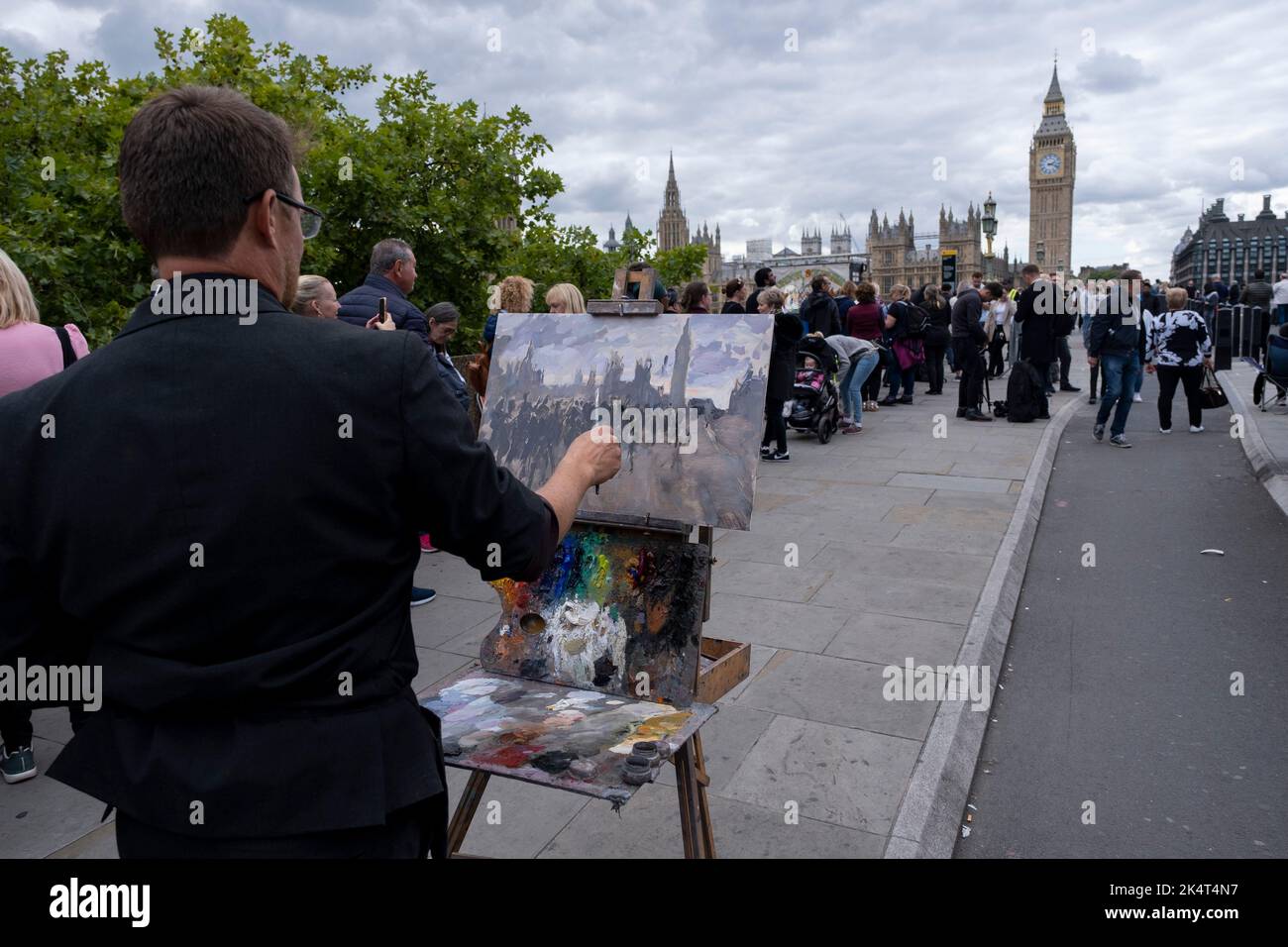Man painting a picture of the scene as long queues of people on the ...