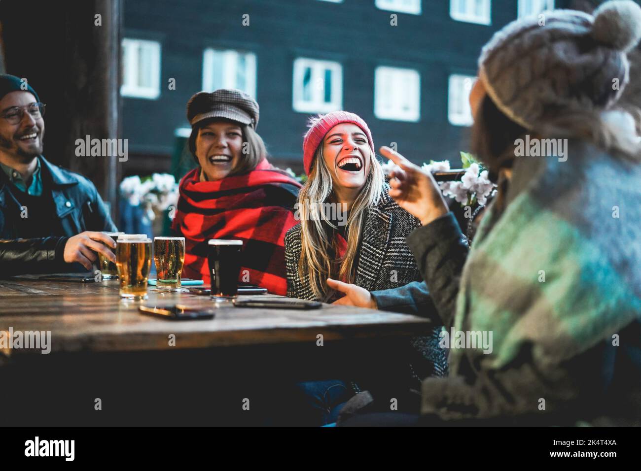 Young people having fun drinking beer at pub restaurant - Soft focus on ...