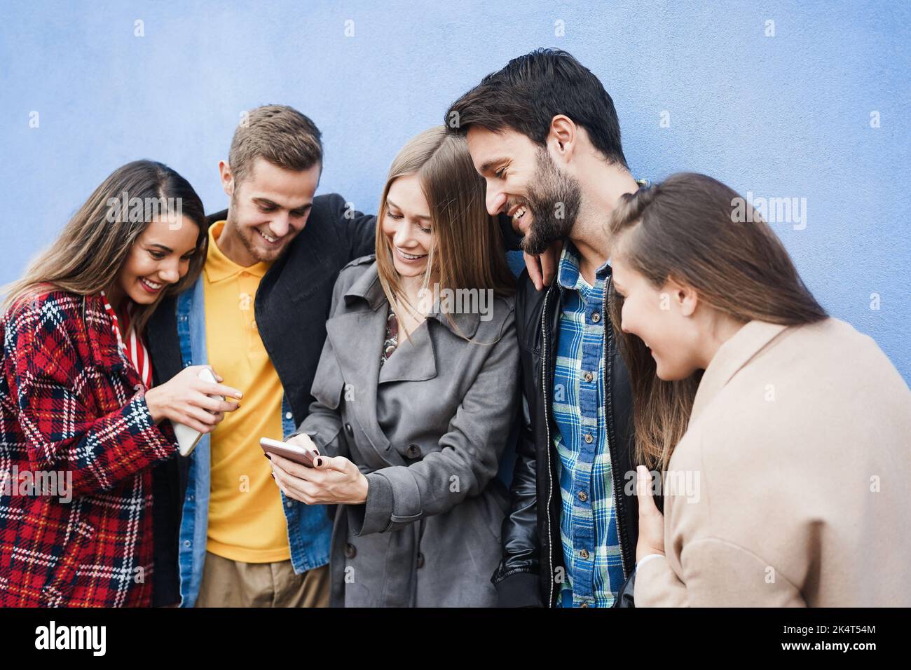 Young friends having fun using mobile phones outdoor - Focus on right ...