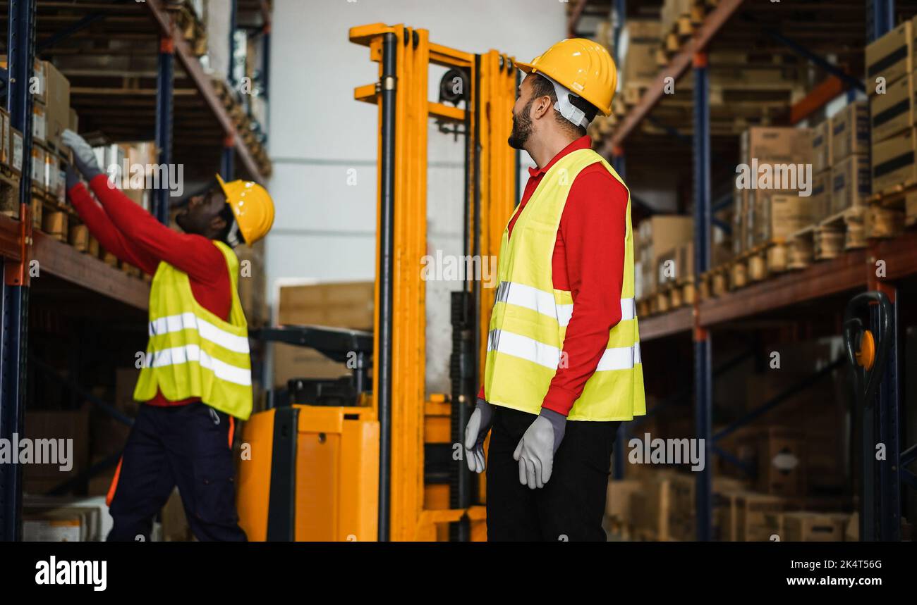 Industrial workers loading delivery box inside warehouse store - Focus ...