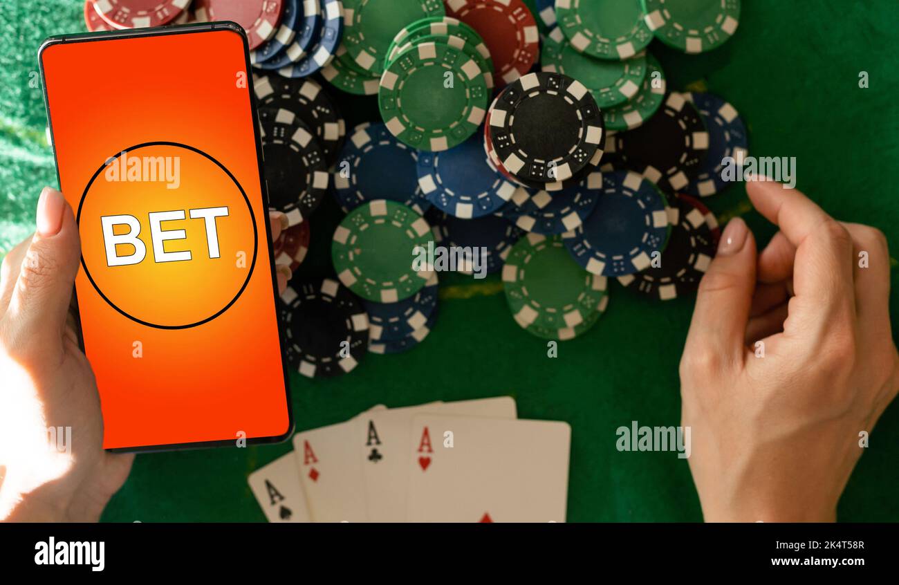 hands of a man holding a online betting device. All screen graphics are ...