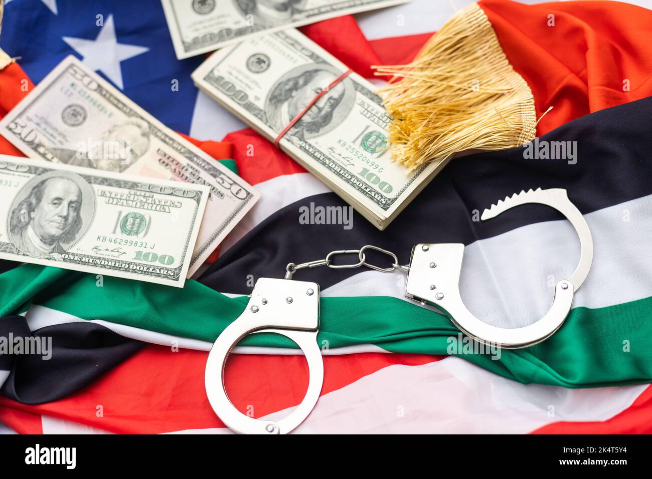 metal handcuff, american dollars cash over flag of USA and UAE flags ...