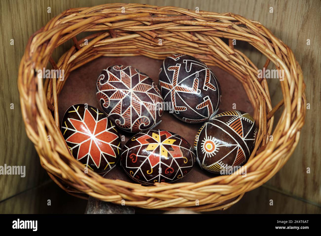 Hand painted ukrainian Easter eggs in wicker basket. Egg decorating in ...