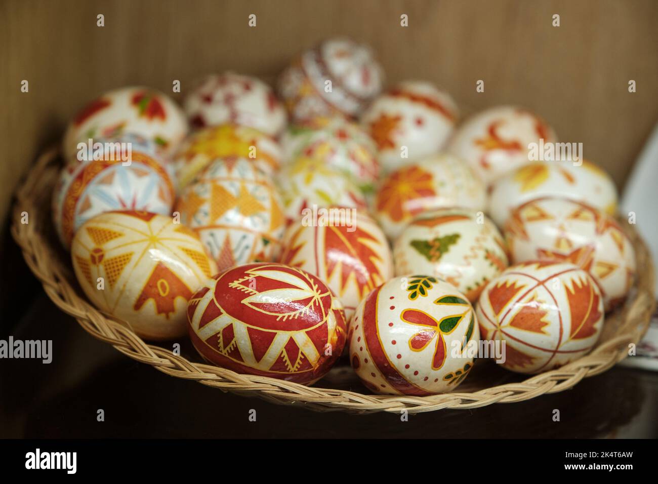 Colorful hand painted Easter Eggs in a wicker bowl. Egg decorating in ...