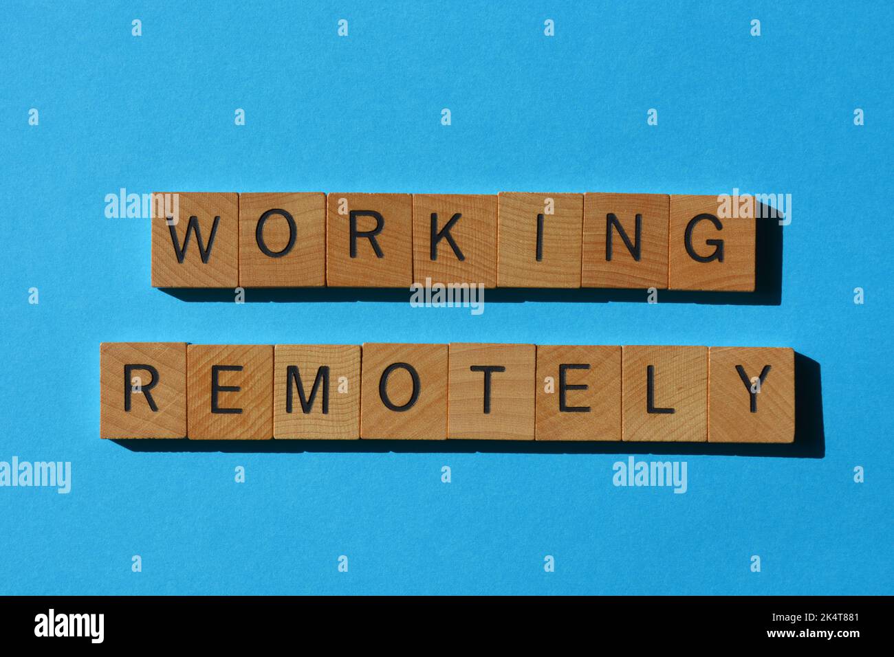 Working Remotely, words in wooden alphabet letters isolated on blue ...