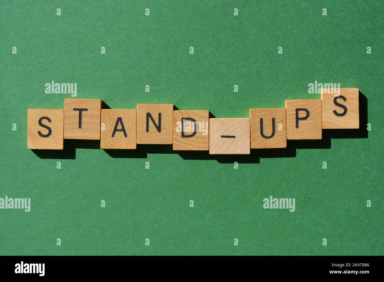 Stand-ups, word in wooden alphabet letters isolated on green background ...