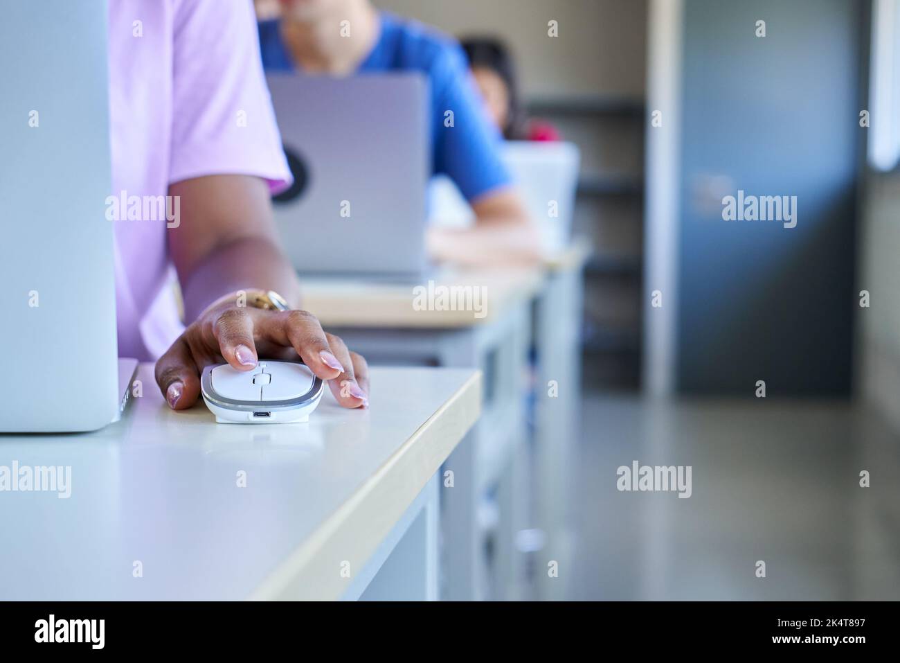 Close up of dark skin hand using computer mouse at classroom ...
