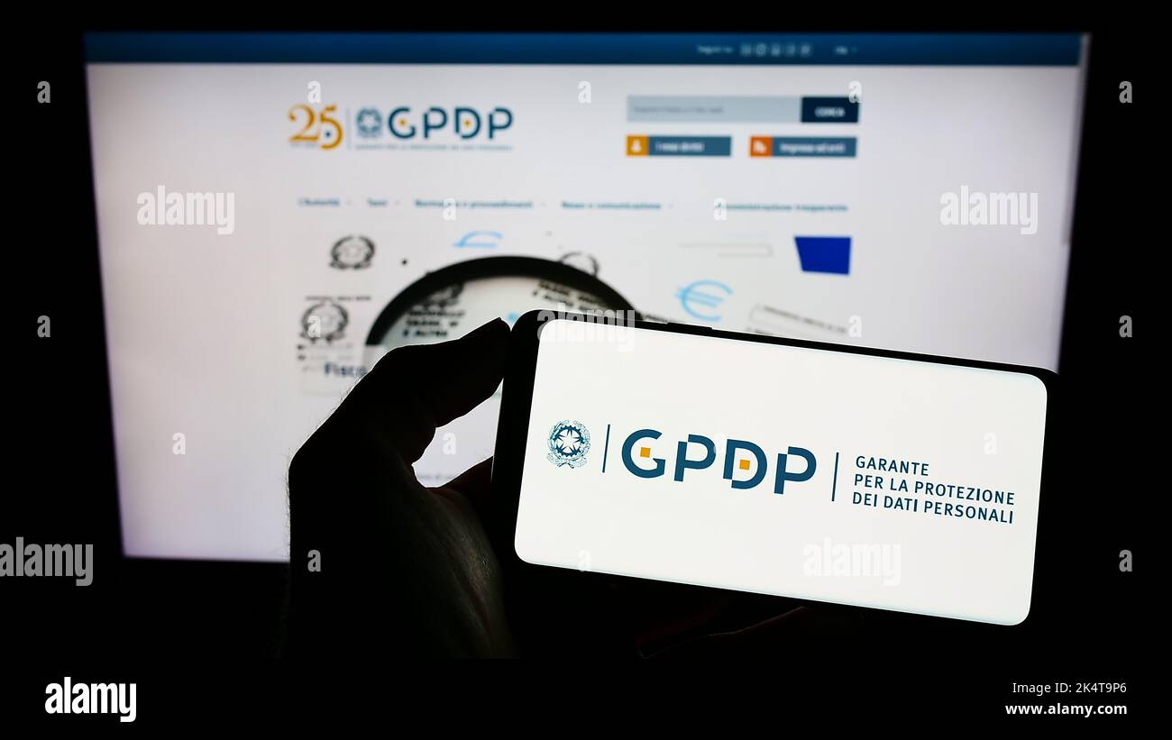 Person holding cellphone with logo of Italian Data Protection Authority ...