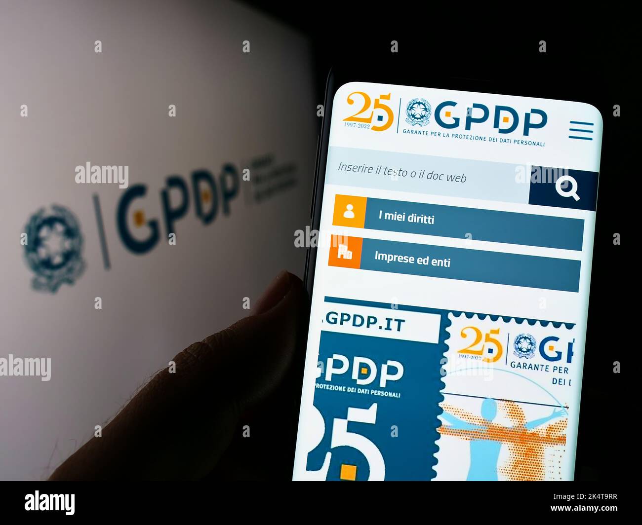 Person holding mobile phone with webpage of Italian Data Protection ...