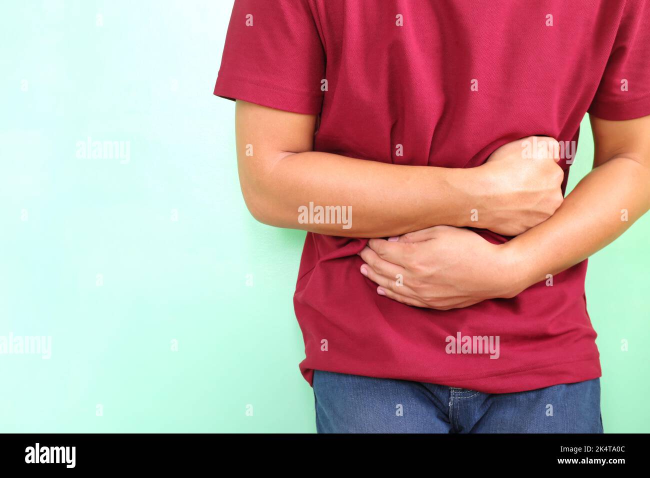 Diarrhea and loose bowel movement concept. Young Asian man holding his ...