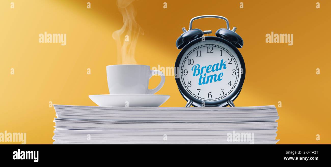 Espresso coffee and alarm clock on a pile of paperwork, it's break time ...