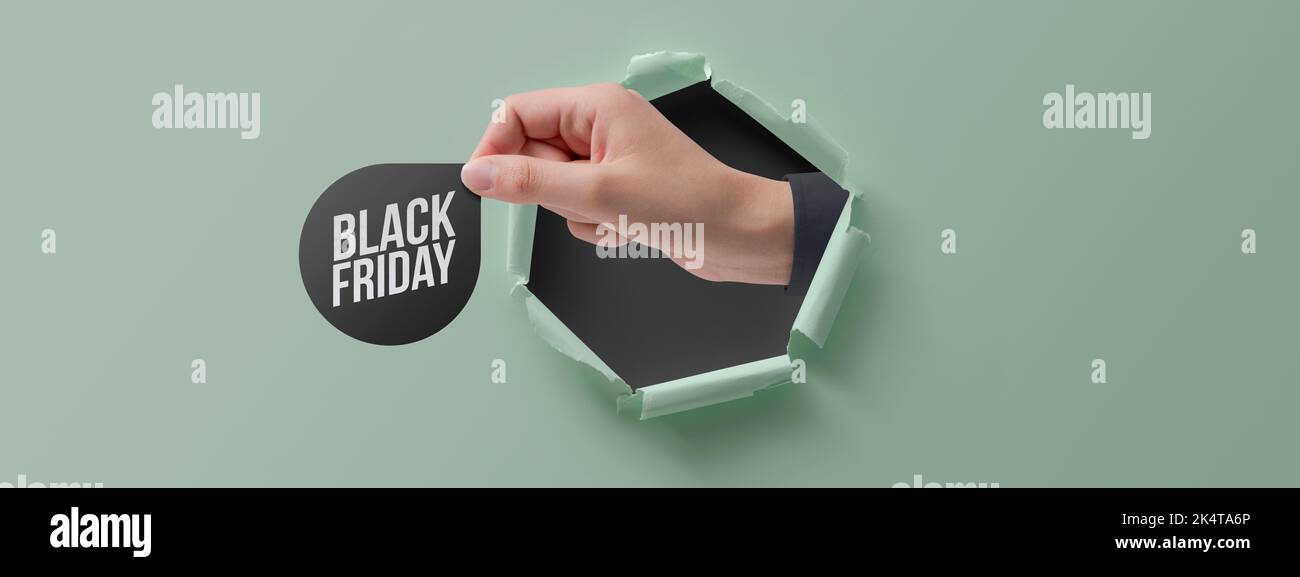 Hand holding a Black Friday promotional label, sales and offers concept ...