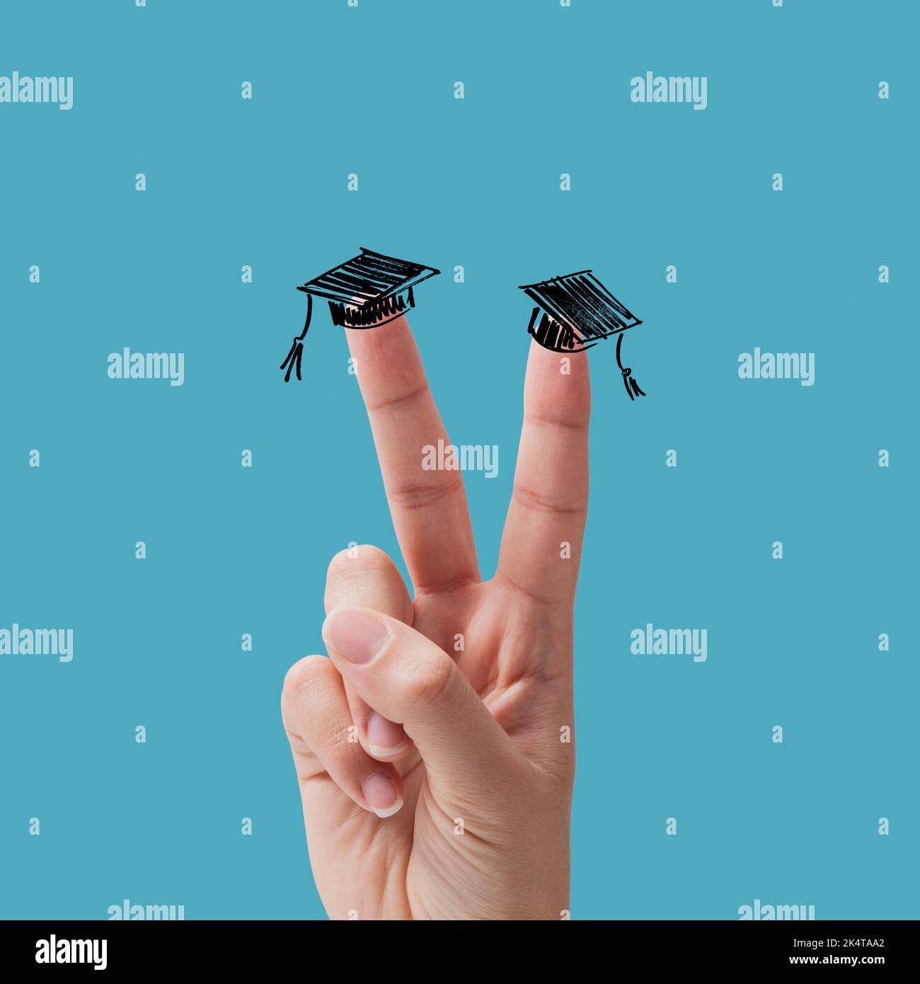 V sign gesture and sketched academic caps on fingers, university and ...