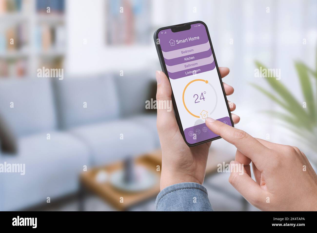 Woman setting home temperature using her smartphone, smart home ...