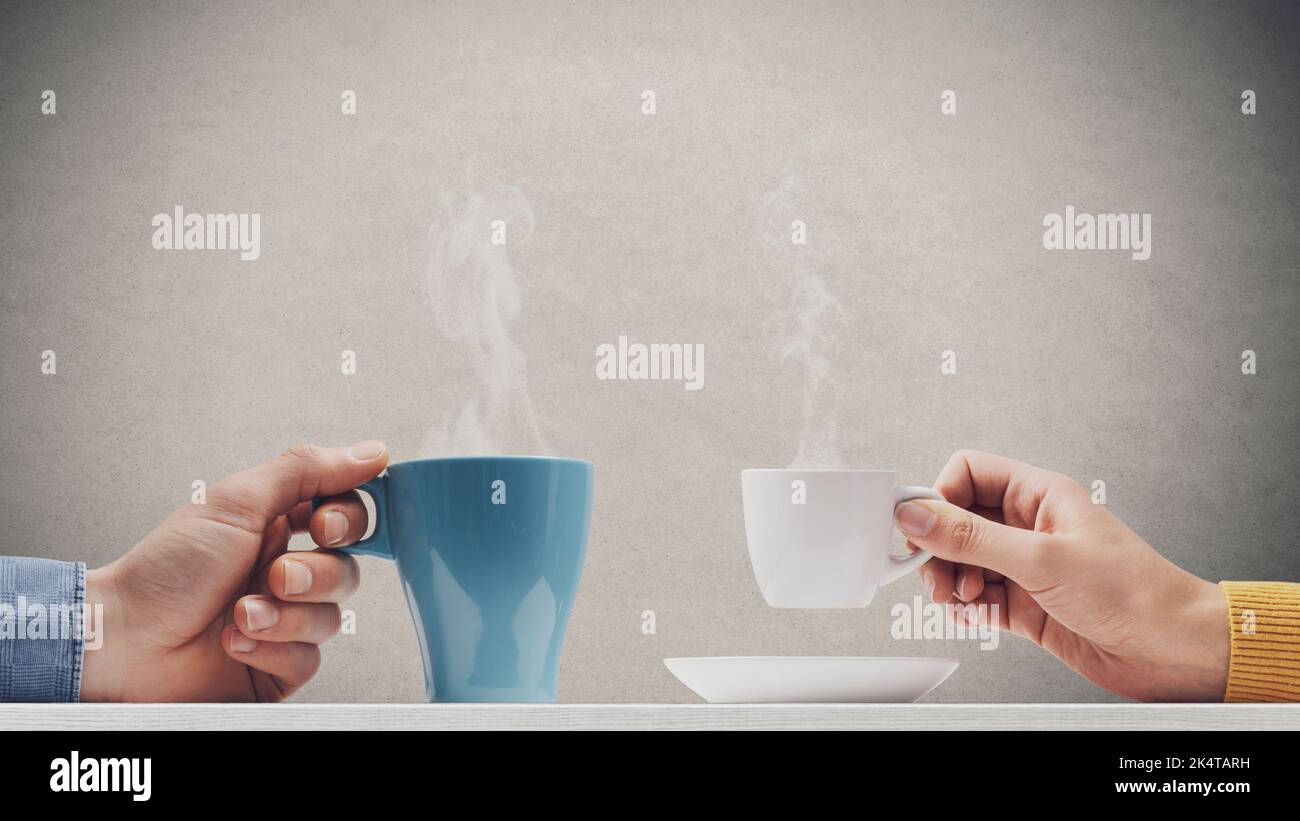 Couple taking a break during work hours, they are drinking coffee ...