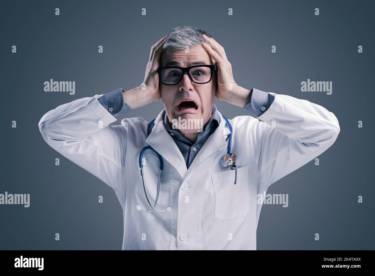 Panicked doctor with head in hands, he is shocked and desperate ...