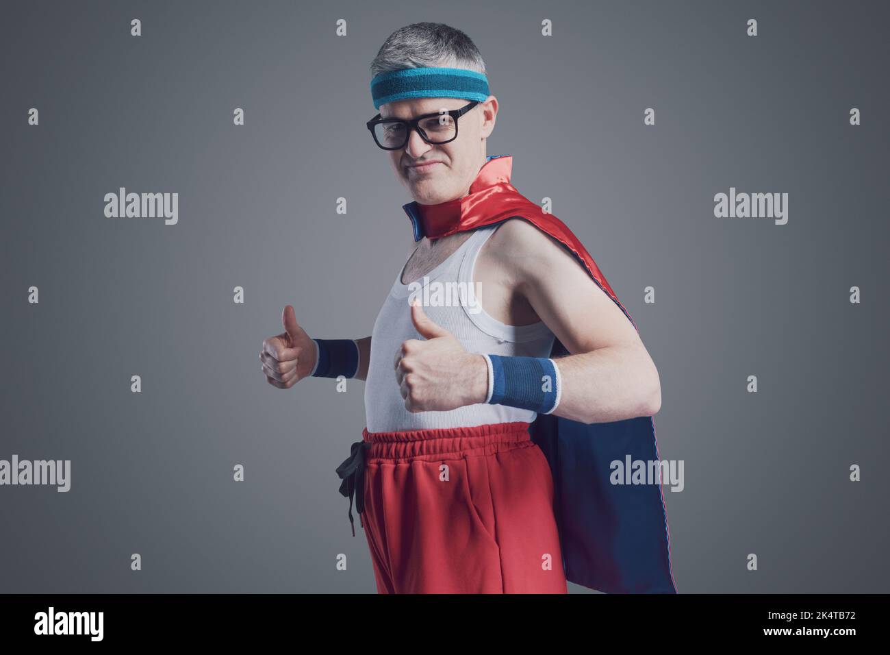 Funny superhero with glasses and cape, he is looking at camera and ...
