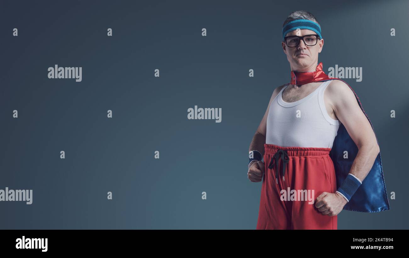 Funny superhero with glasses and small cape, he is posing and looking ...