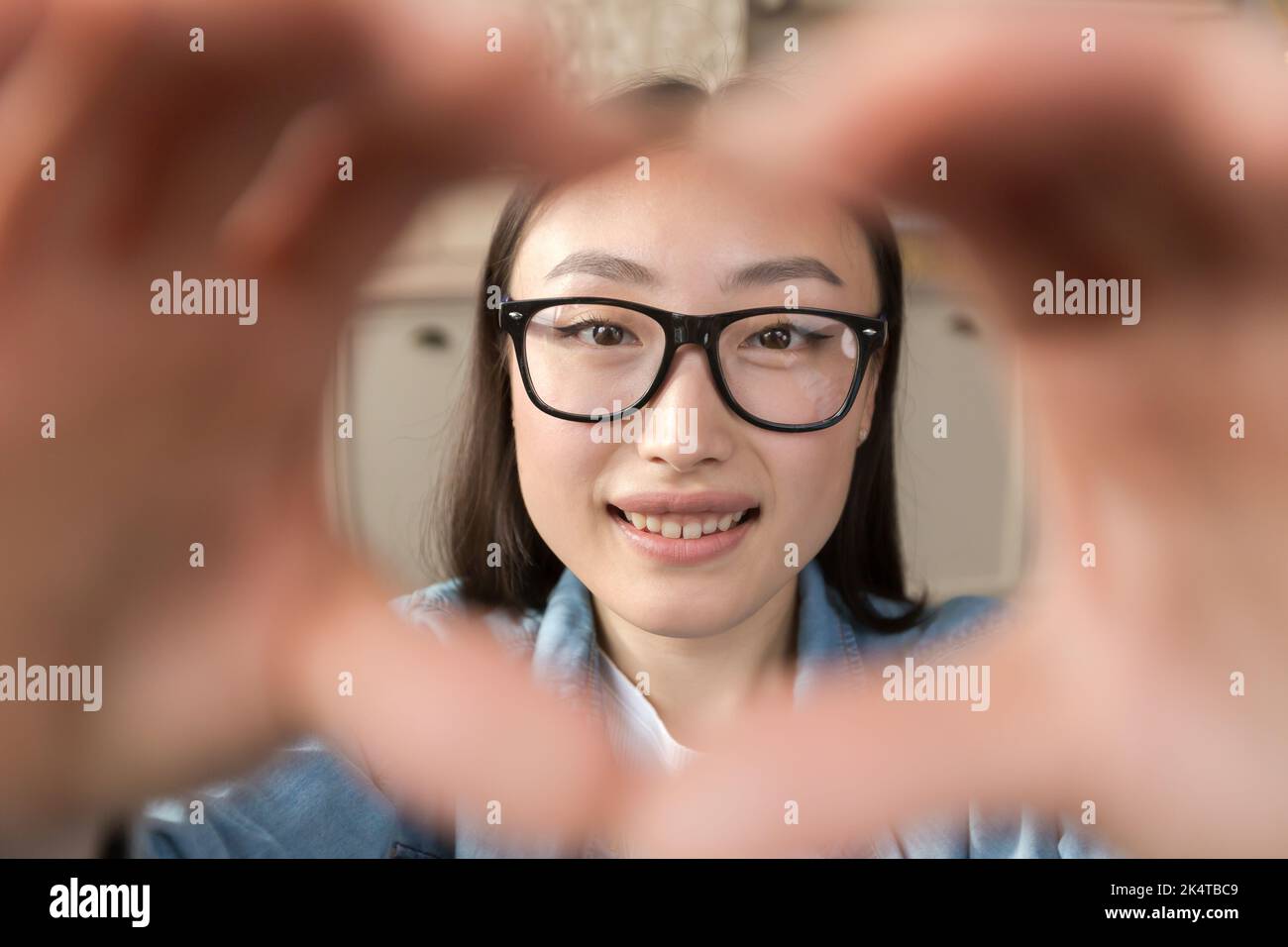 Close-up photo portrait of young beautiful Asian woman looking at camera and smiling, teenage ...