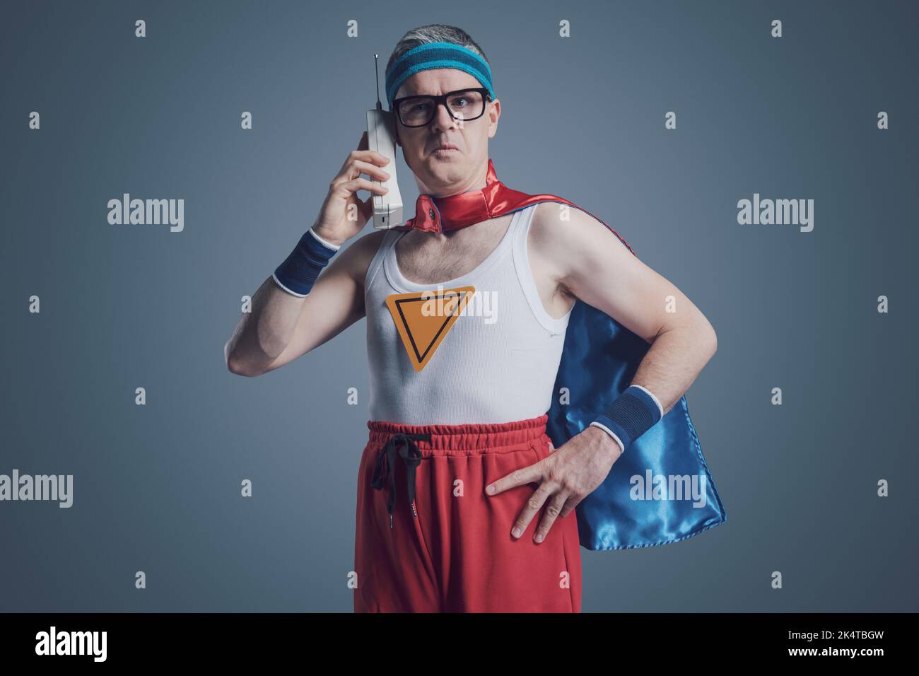Superhero making a phone call using an old obsolete cordless telephone ...