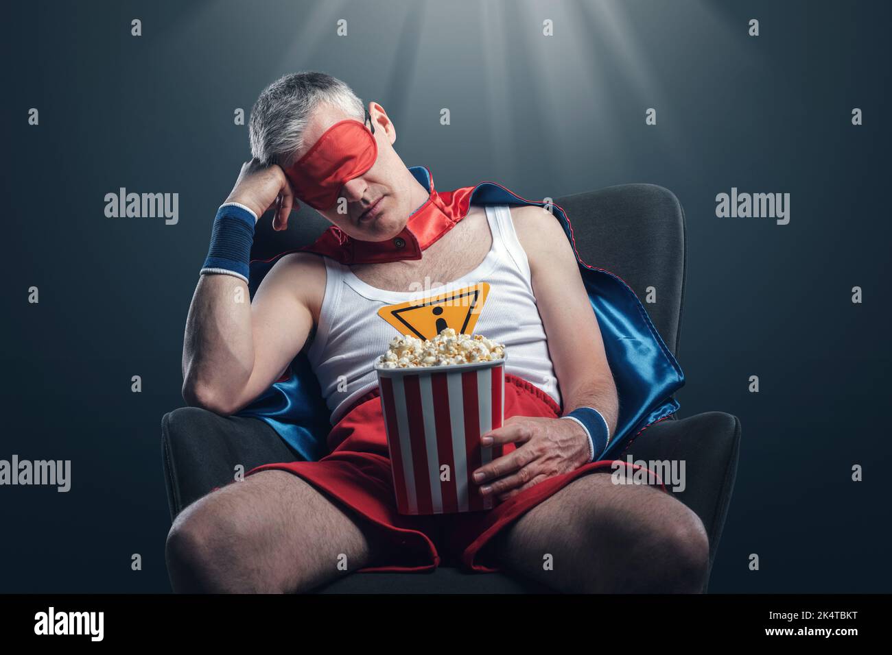 Funny superhero watching a boring movie, he is sleeping with a sleep ...