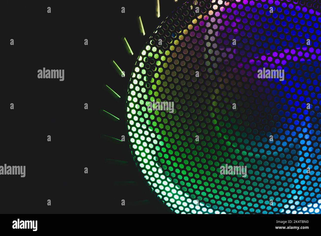 Colorful led lights of computer fan shines through the protective grid ...