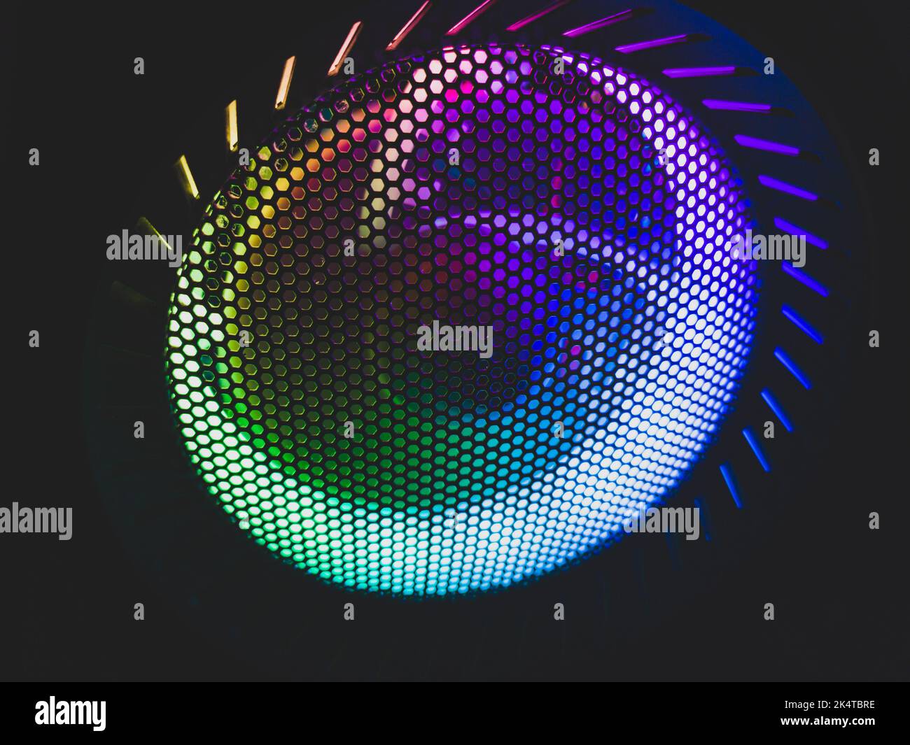 Colorful led lights of computer fan shines through the protective grid ...