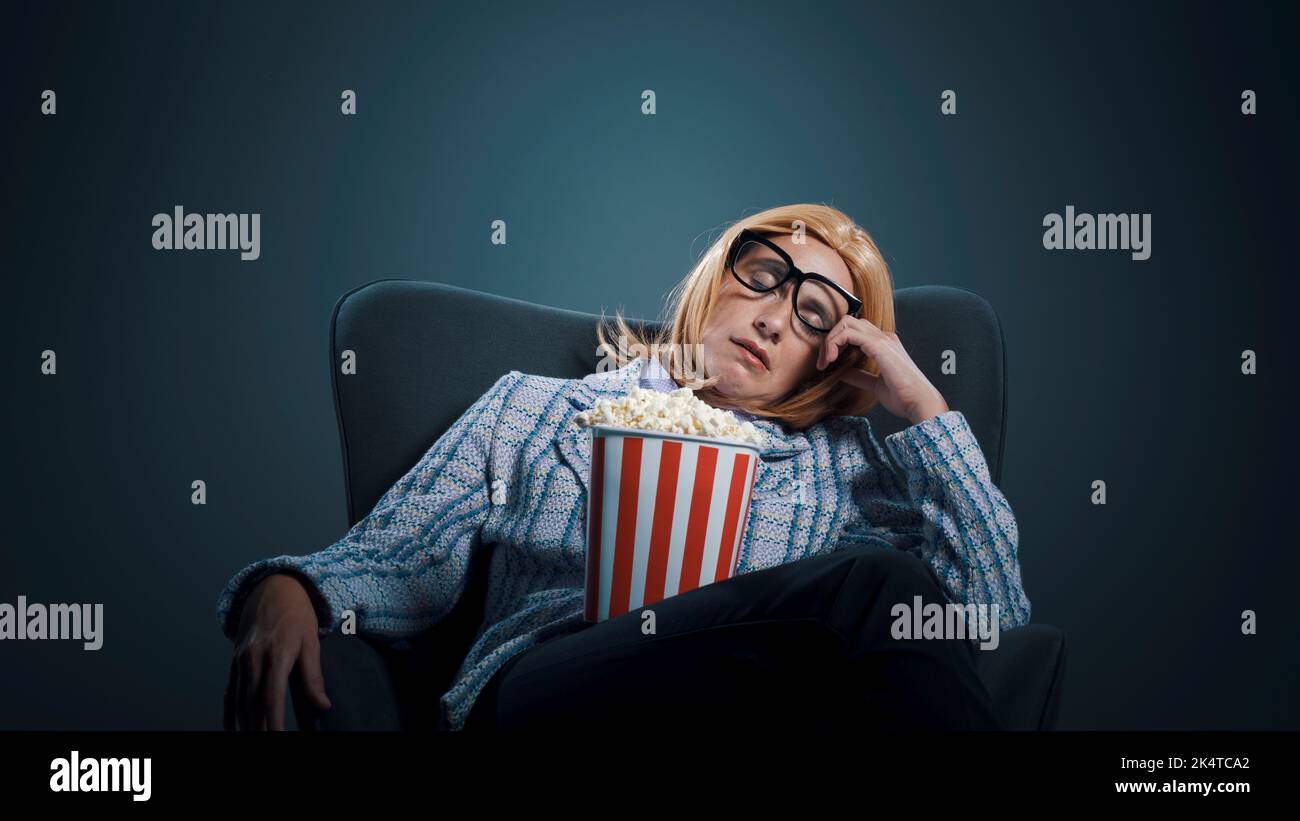 Bored woman at the movie theater, she watches a boring movie and falls ...