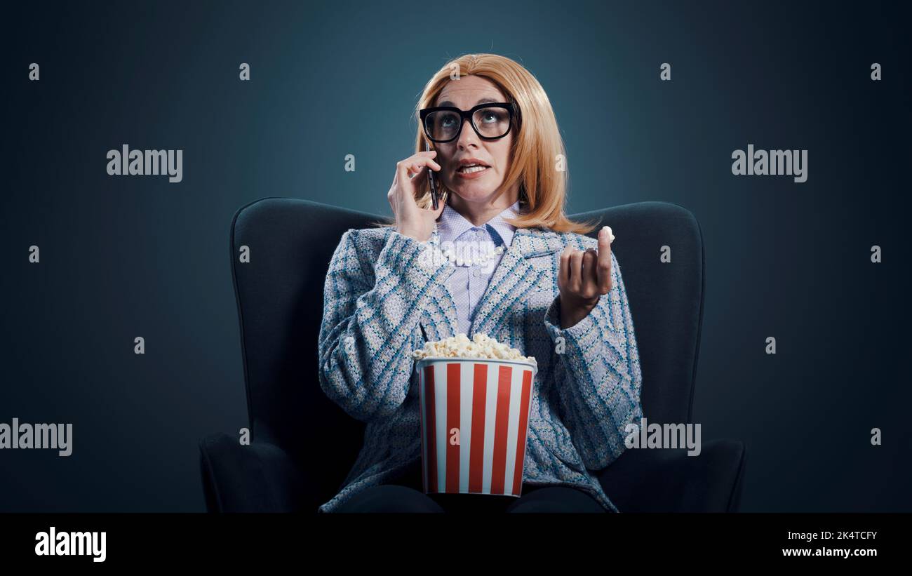Funny rude woman talking with her smartphone at the movie theater Stock ...
